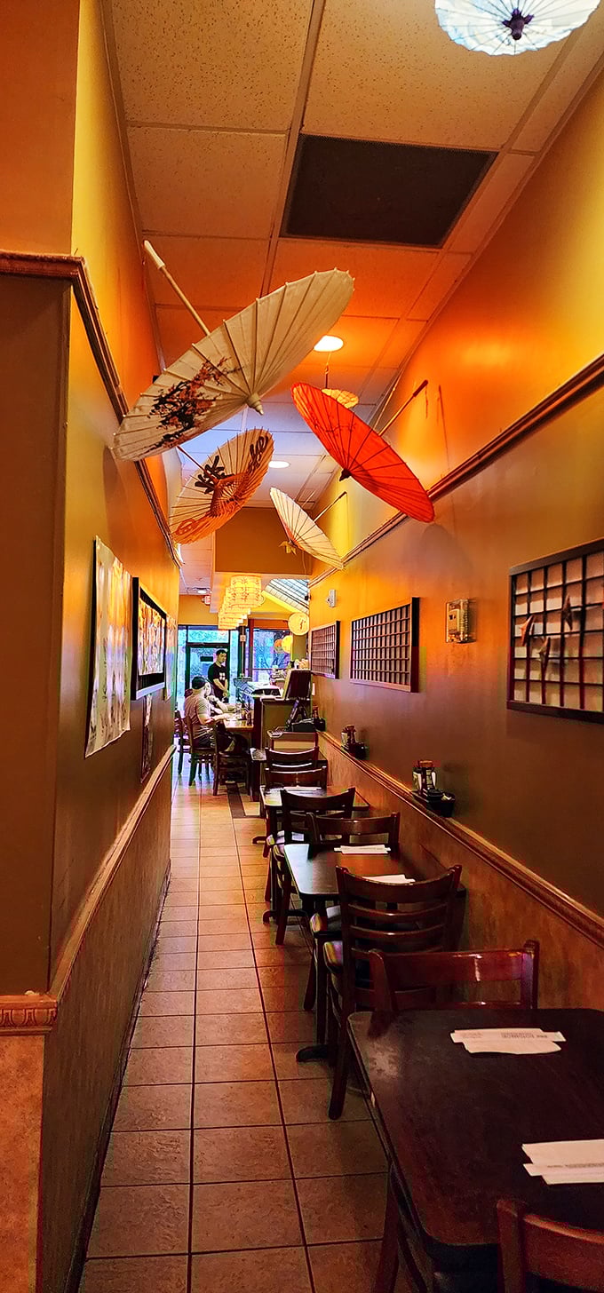 The narrow dining corridor with floating paper umbrellas overhead creates an intimate journey through Japanese aesthetics. Pure magic.