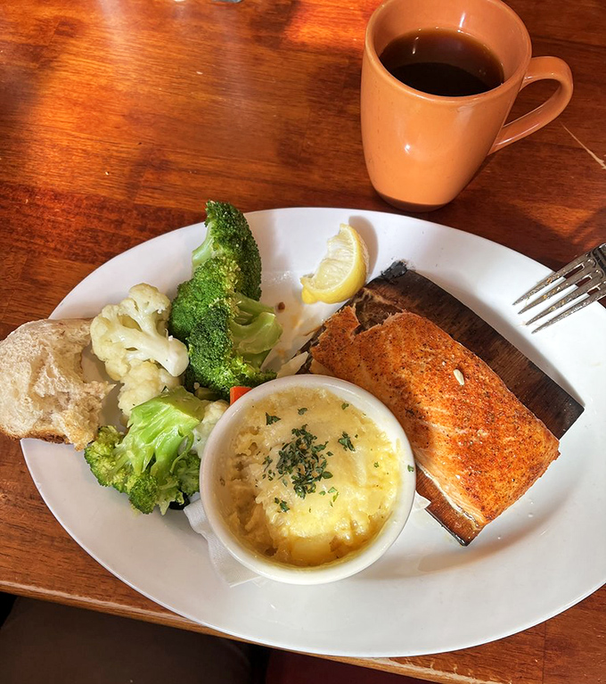 Blackened salmon that's found its perfect companions in steamed vegetables and a side that's whispering, "You made the healthy choice... mostly."