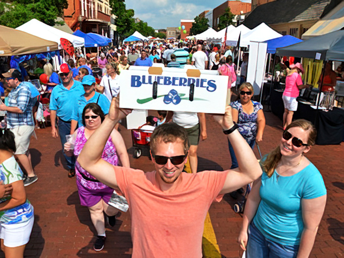 At the Blueberry Festival, happiness is measured by the bucket. That smile says he's struck blue gold in the oldest town in Texas.