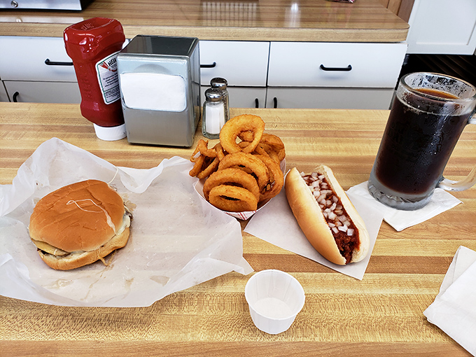 The perfect trifecta: a humble burger, crispy onion rings, and a coney dog, all washed down with root beer. Some call it lunch; Michiganders call it paradise.