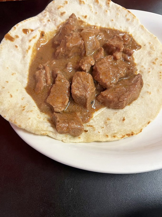 Carne guisada on a homemade tortilla—tender beef that surrendered to slow-cooking and spices long ago. Resistance is futile.