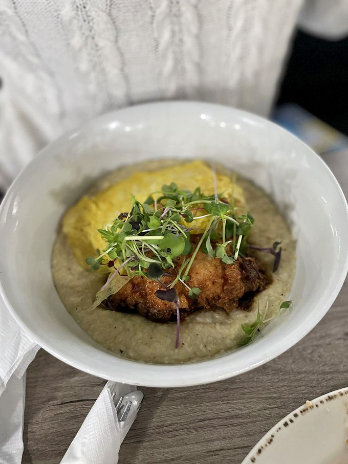 Crispy chicken nestled on a bed of creamy grits, topped with microgreens&mdash;proof that comfort food and elegance aren't mutually exclusive.