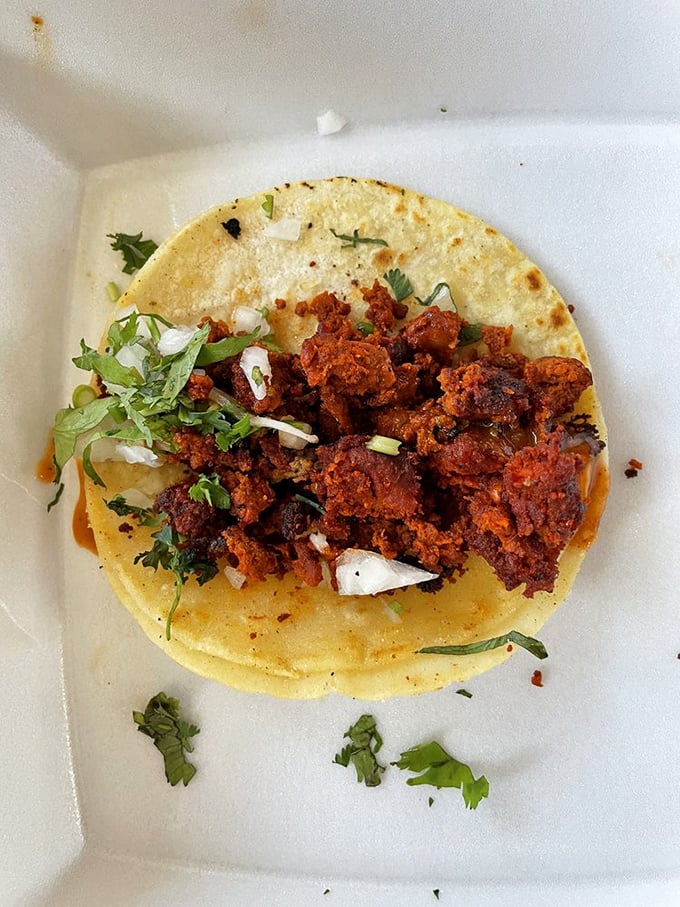 This chorizo taco isn't just red &ndash; it's a vibrant declaration of spicy independence. The scattered cilantro adds freshness to balance the rich, smoky meat.