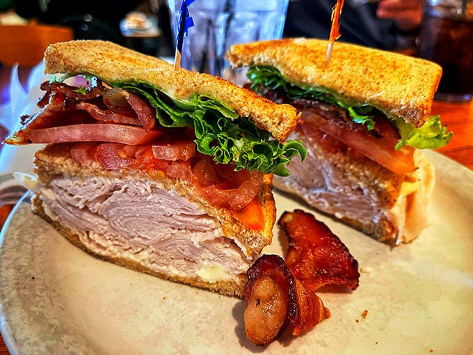 A club sandwich so substantial it needs those toothpicks as structural support. This isn't lunch—it's an engineering project you can eat.