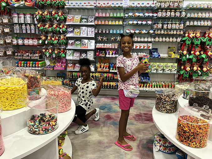 Young candy enthusiasts plotting their sugar strategy amid a wonderland of options&mdash;childhood joy distilled into its purest form.