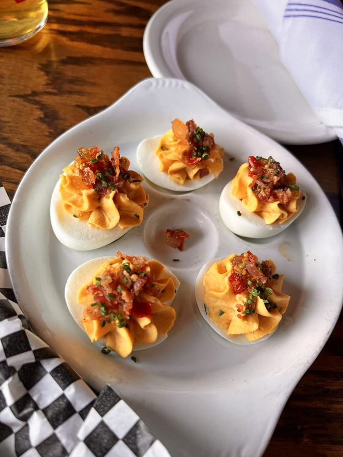 Deviled eggs elevated to an art form &ndash; creamy filling piped with precision and topped with bacon bits that add the perfect salty finish.