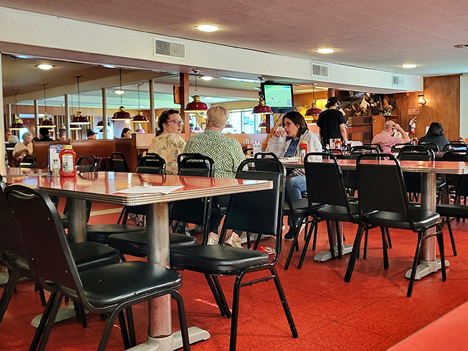 The dining room hums with conversation and the clinking of forks &ndash; a community gathering place where strangers become neighbors over chicken.