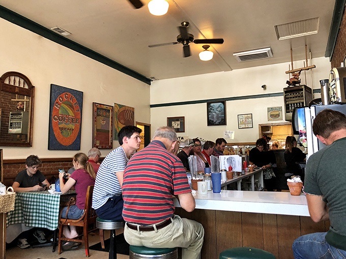 The counter seating: where solo diners become temporary family and coffee refills flow like conversation. Notice the "Coffee Pot" sign watching over all.