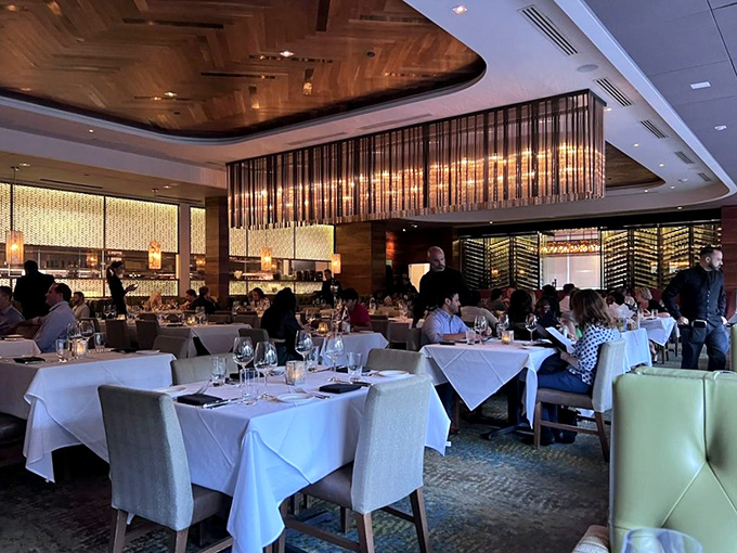 Diners basking in the warm glow of good decisions and great lighting. Wine glasses stand at attention, ready for their supporting role.