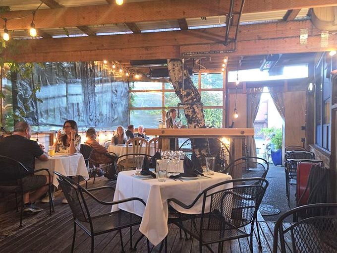 The evening transforms this space into an intimate dinner setting where white tablecloths signal a shift from casual breakfast to something more refined.