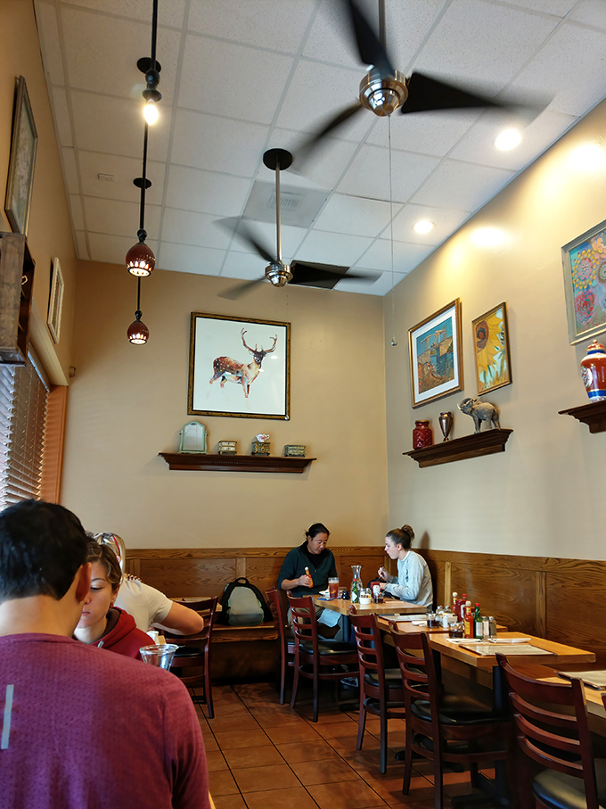Under the watchful gaze of artistic deer, diners engage in the universal ritual of breakfast appreciation.