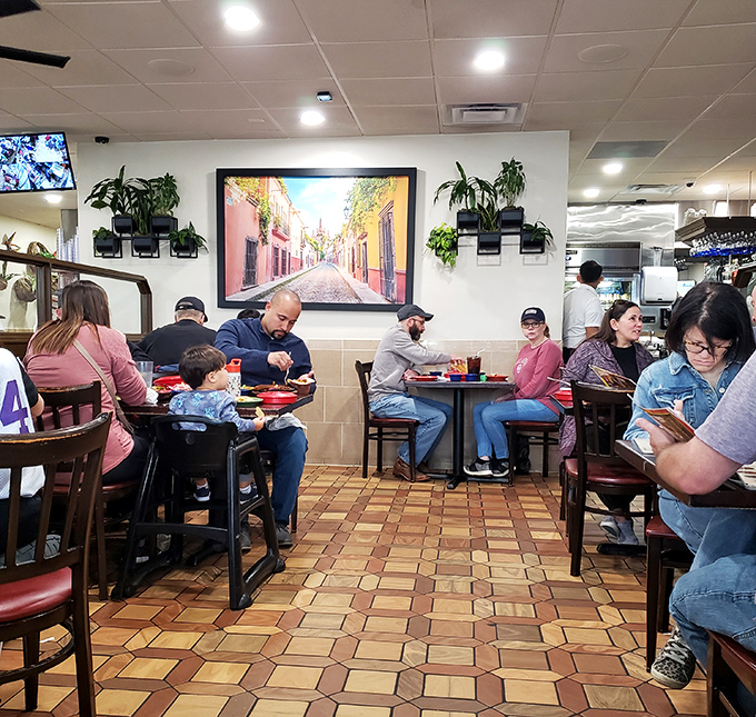 Families gather around colorful tables, sharing meals and memories. That vibrant artwork transports diners straight to a Mexican street scene without leaving Oklahoma.
