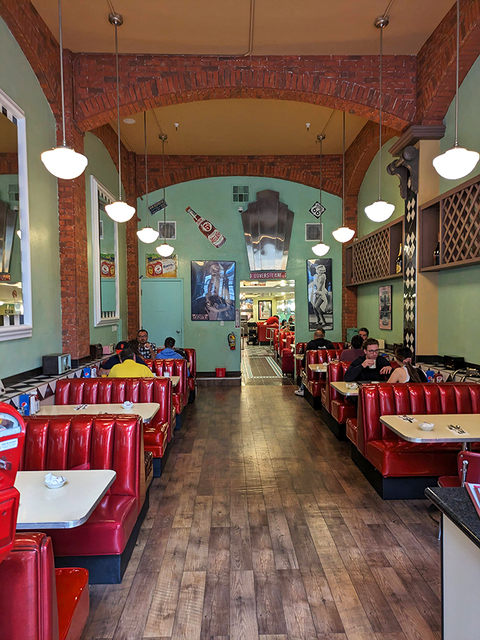 The dining room hums with conversation under exposed brick arches, where every booth feels like the best seat in the house.
