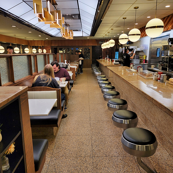 Modern pendant lighting meets timeless diner charm, creating an atmosphere where every seat feels like the best seat in the house.