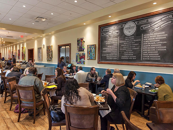 The chalkboard wall showcases local purveyors while diners engage in that universal restaurant activity&mdash;ignoring their companions for the food.