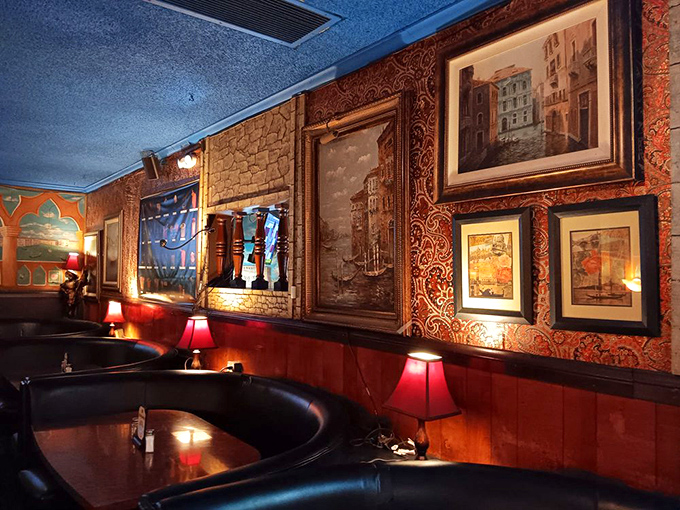 Red leather booths cradle conversation beneath the warm glow of table lamps, while Venice-inspired artwork transforms mundane Tuesday dinners into special occasions.