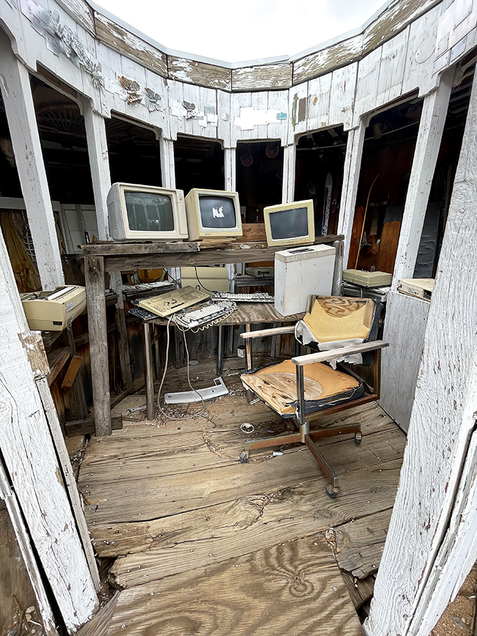 Technology's retirement home. Vintage monitors and keyboards create an eerie control center where the only commands now come from the desert wind.