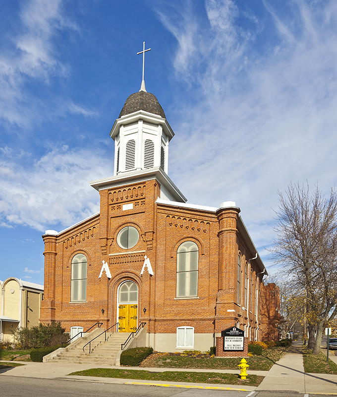 This church's yellow door offers a sunny welcome against its warm brick facade. Spiritual sanctuary with architectural personality.