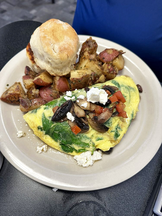 An omelet stuffed with vegetables and feta alongside seasoned potatoes and a fresh biscuit. Breakfast architecture at its finest&mdash;sturdy foundation, excellent filling. 