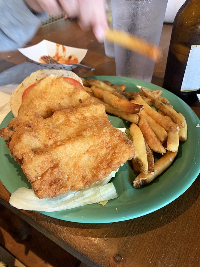A fish sandwich that requires a game plan before the first bite. This golden-fried grouper doesn't just hang over the bun &ndash; it establishes dominance.