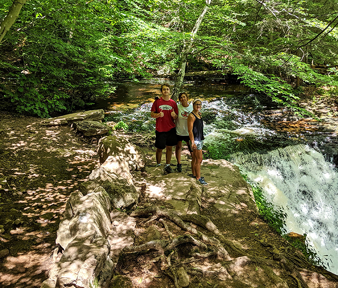 A peaceful moment beside one of the smaller cascades proves that sometimes the supporting actors deserve just as much attention as the star attraction.