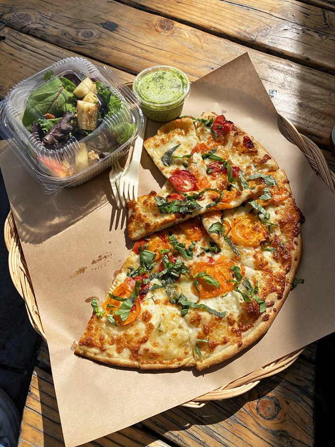 A half-moon of perfection with a side of greens. Balance in all things, especially when the pizza is this good.