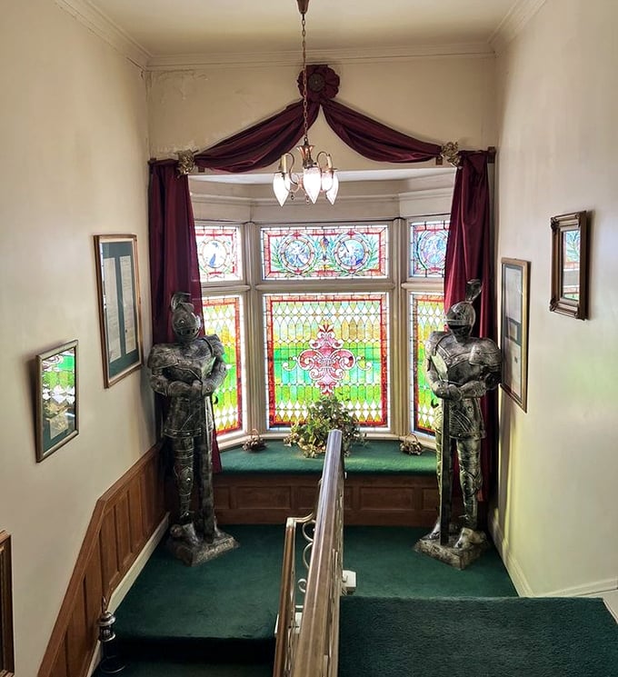Knights in shining armor flank a stained glass window, standing sentinel over a staircase that's seen more than a century of footsteps.