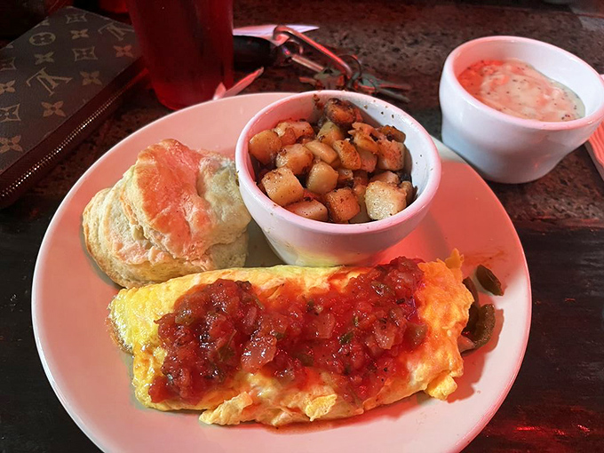 Morning masterpiece: fluffy eggs, crispy potatoes, and a biscuit that would make your grandmother nod in approval.