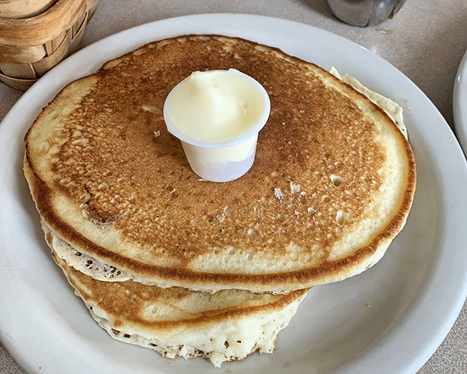 These golden pancakes stand tall and proud, like edible monuments to the breakfast gods who blessed us with simple morning pleasures.
