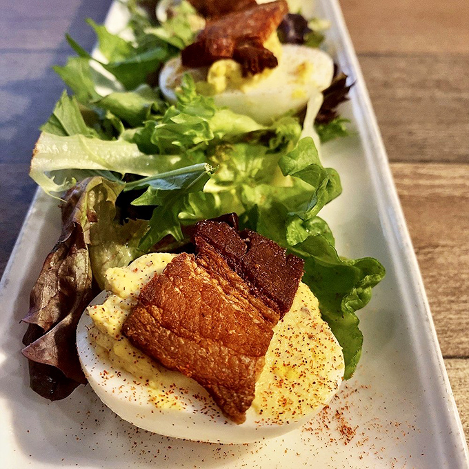 Deviled eggs living their best life with crispy pork belly on top. These aren't your church picnic appetizers&mdash;they've gone to finishing school.