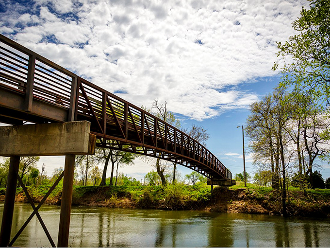 A pedestrian bridge spans the gentle current of the Black River, connecting trails and offering contemplative views of Poplar Bluff's natural backdrop.