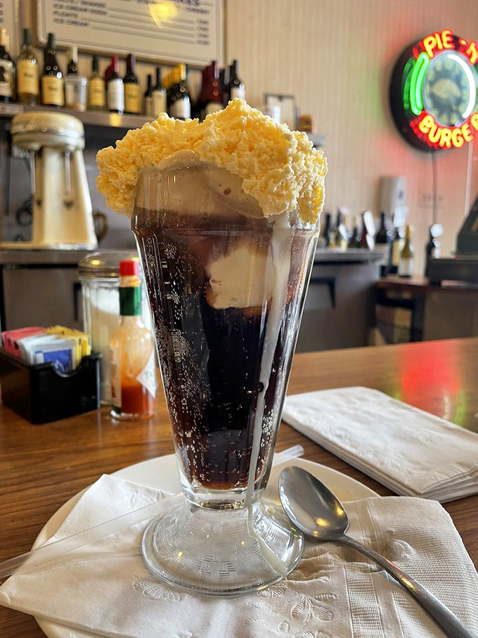 The root beer float arrives like a science experiment gone deliciously right, crowned with a cloud of vanilla ice cream melting into carbonated bliss.