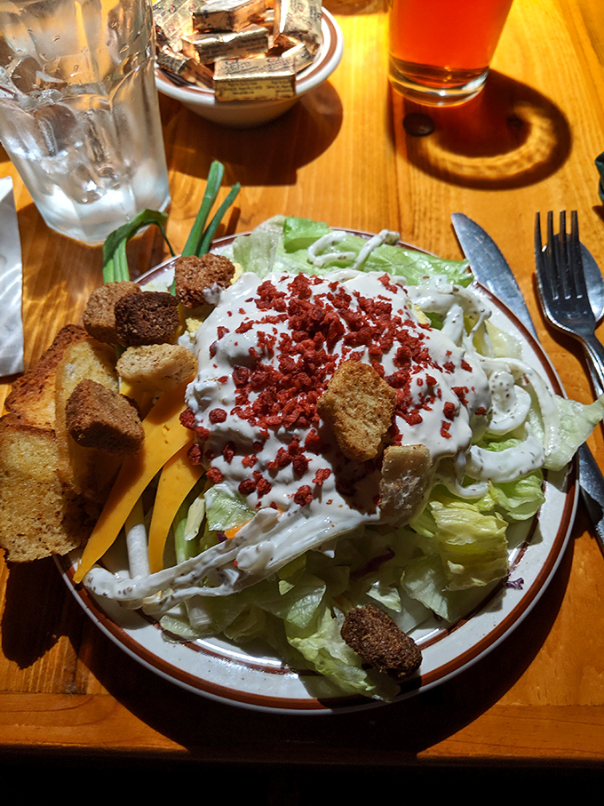 A salad that doesn't apologize for wearing its dressing proudly, topped with bacon bits like confetti at a celebration.