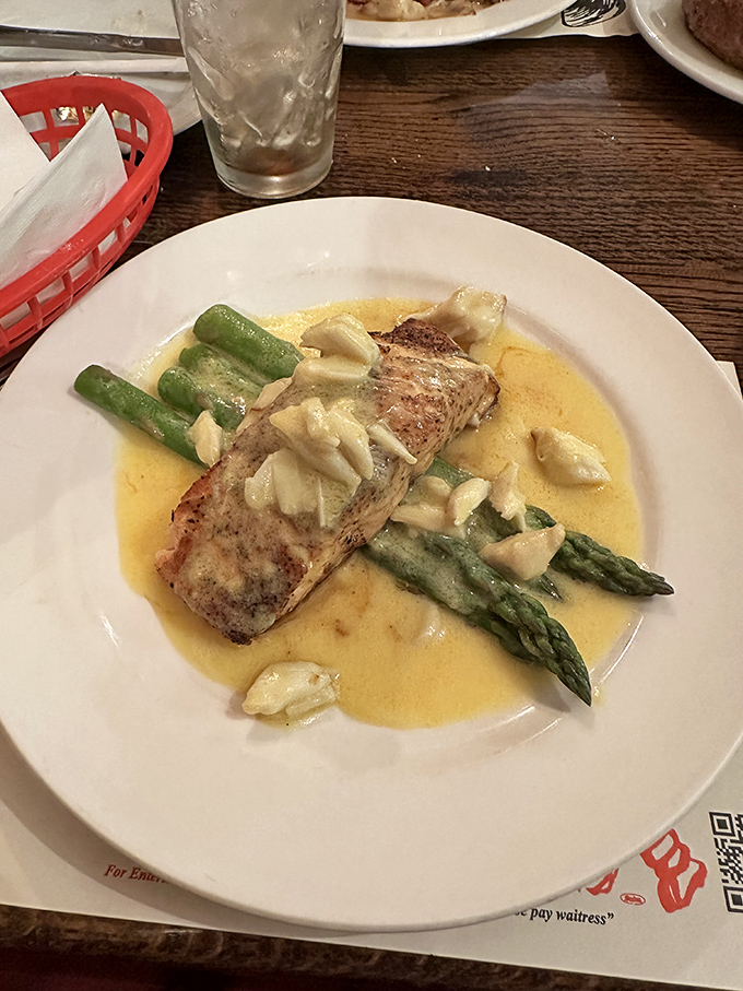 This delicate fish fillet swimming in buttery sauce with fresh asparagus isn't just dinner&mdash;it's edible poetry on a white plate.