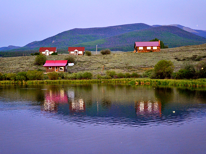 Soward Ranch cabins reflect perfectly in still waters, creating the kind of mirror image that makes photographers forget to actually take the picture.