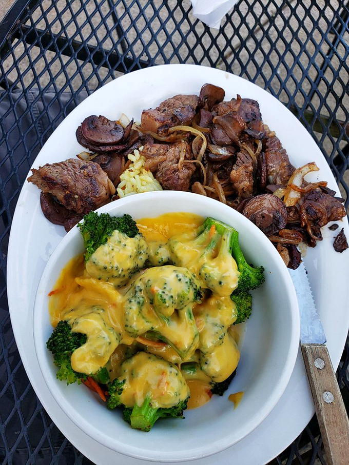 Proof that barbecue joints can do vegetables right: cheese-draped broccoli alongside smoky steak tips. Your doctor would be... confused.