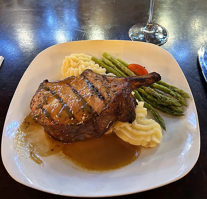 This isn't just a pork chop&mdash;it's meat architecture, perfectly balanced on a cloud of mashed potatoes with asparagus standing guard.