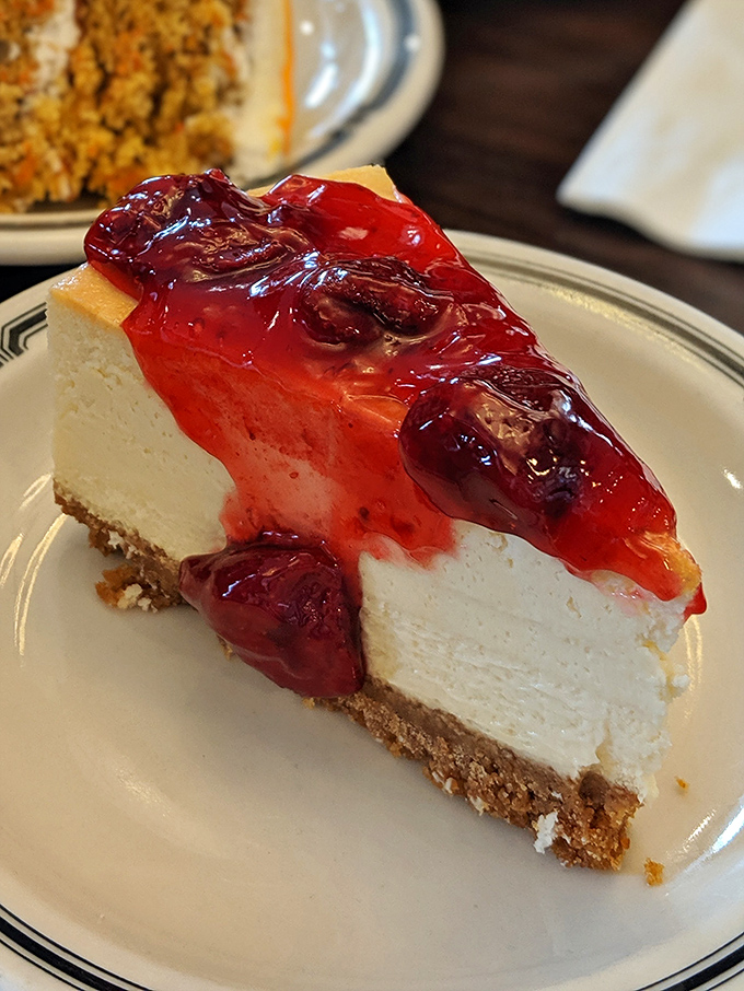 A slice of cheesecake that makes all other desserts seem like they're not even trying. That strawberry topping is the ruby crown on creamy perfection.