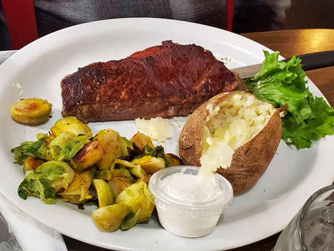 A perfectly seared steak with a loaded baked potato and roasted brussels sprouts. Comfort food elevated without any unnecessary fussiness.