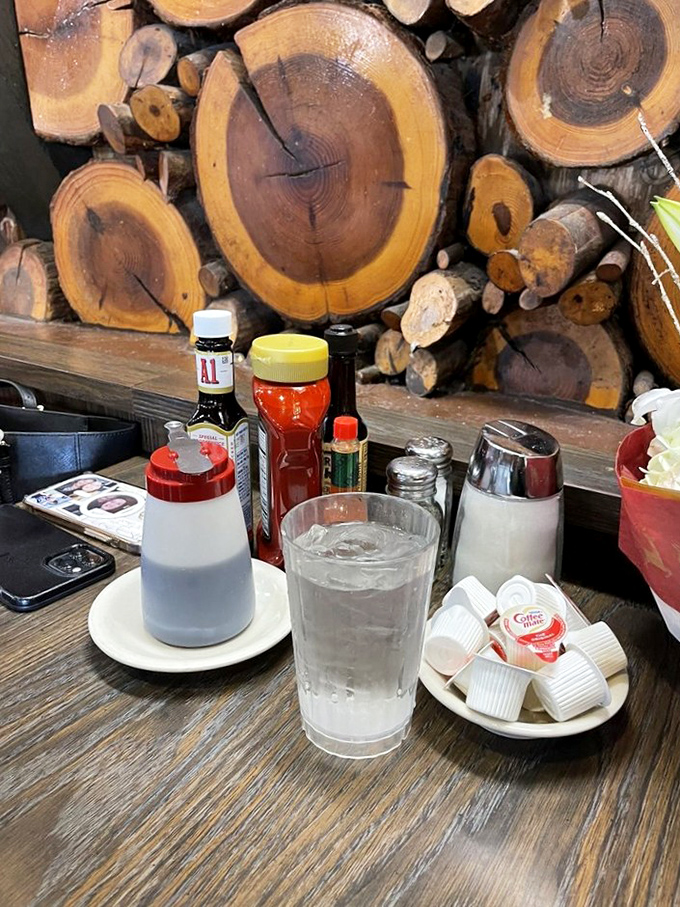 The wood cross-section wall creates a rustic backdrop for table essentials &ndash; like dining in a cozy cabin where breakfast is always the main event.
