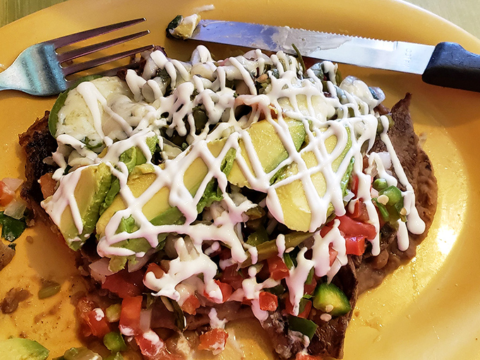 Layers of flavor built like a delicious architectural marvel. The avocado and sour cream drizzle turn this tostada into edible art.