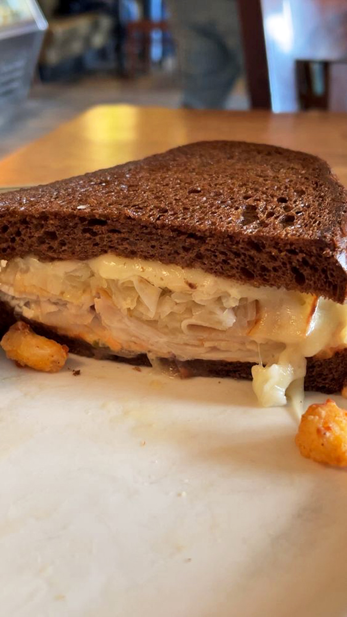 A sandwich that understands balance &ndash; hearty rye, tangy sauerkraut, and cheese that doesn't just participate but leads the flavor parade.