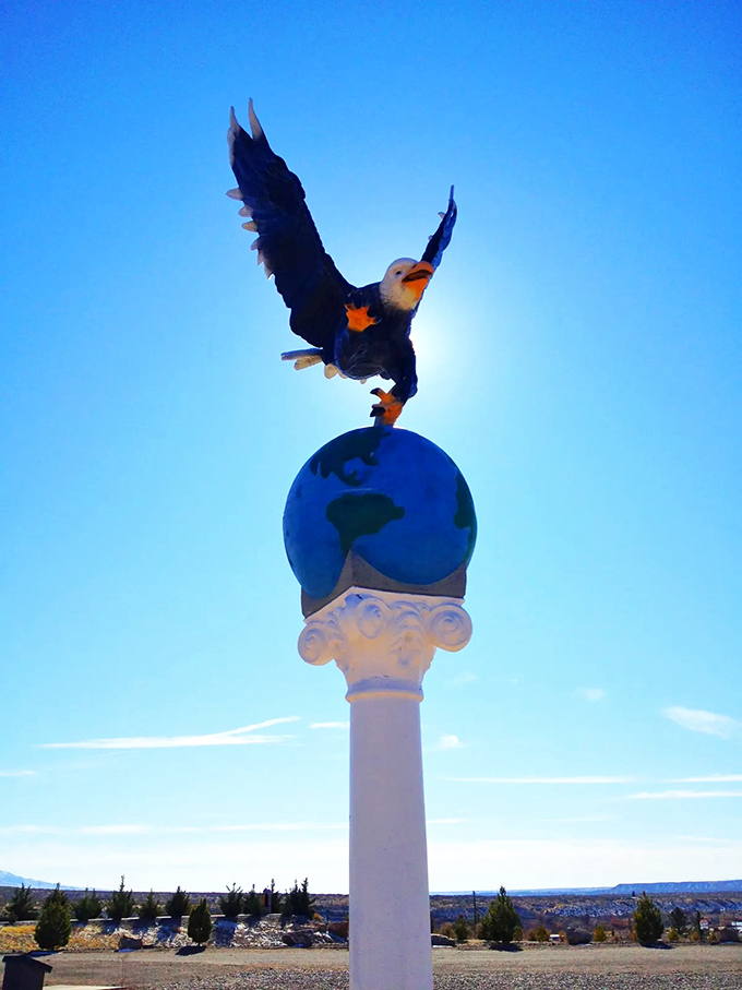 This majestic eagle statue reaches for the sky, a powerful symbol perched atop the world, silhouetted against New Mexico's perfect blue.