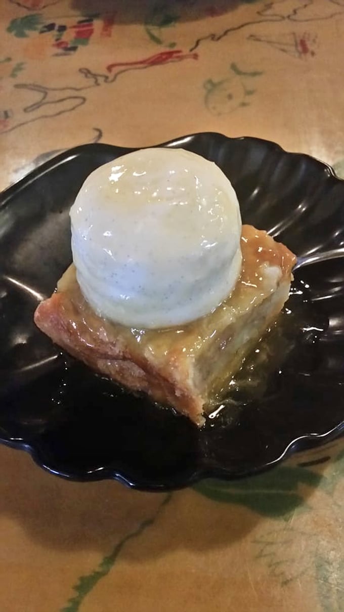White chocolate bread pudding topped with vanilla ice cream—proof that sometimes dessert is the main event masquerading as the finale.