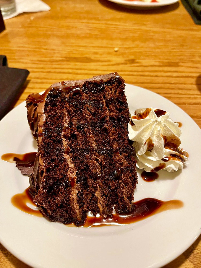 This isn't just chocolate cake&mdash;it's a monument to cocoa, layered with frosting and drizzled with sauce that makes spoons move involuntarily toward plates.
