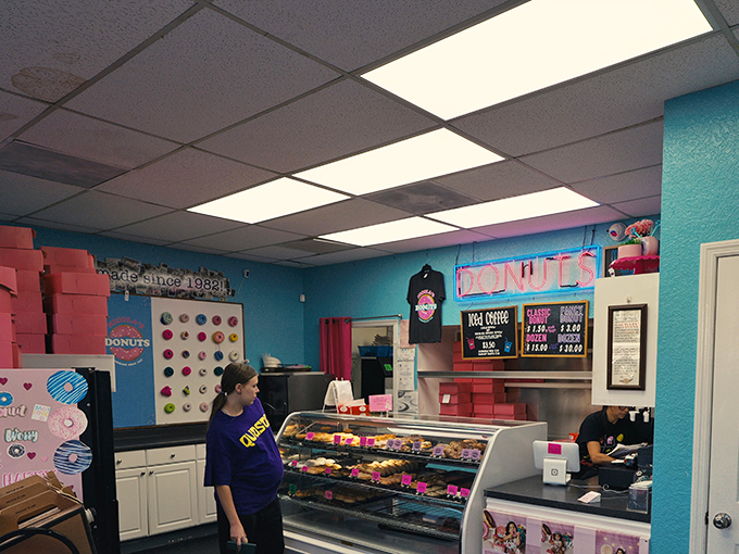 The donut counter experience&mdash;where anticipation and neon lighting create the perfect atmosphere for life-changing pastry decisions.