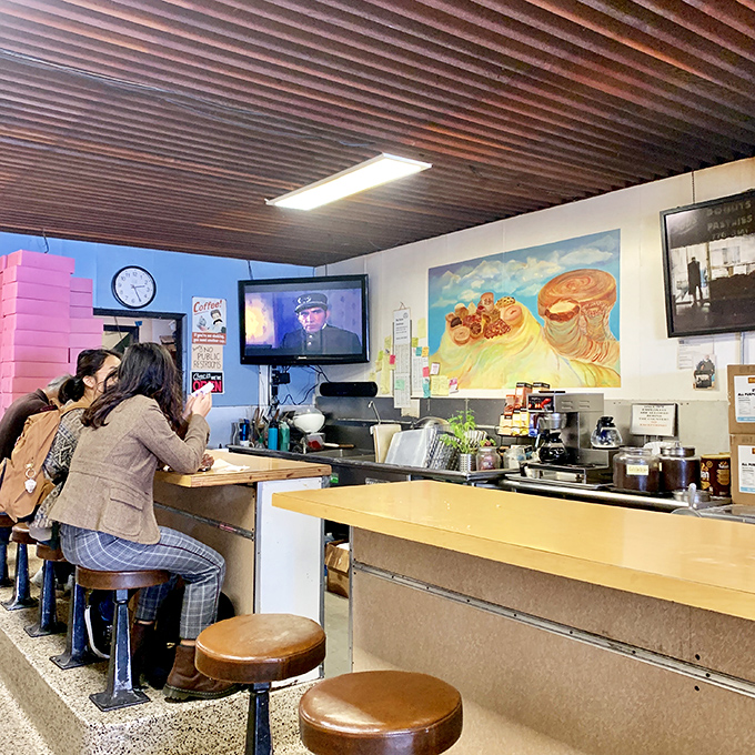 Local regulars gather at the counter, sharing the universal language of appreciation for exceptional baked goods.