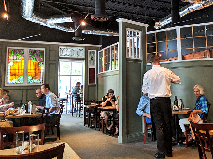 The stained glass dividers and sage green walls create intimate dining nooks where serious food conversations happen. "Did you try the mac and cheese yet?"