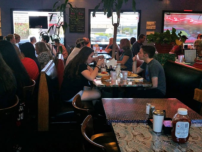A bustling dining room where strangers become temporary tablemates, united by the universal language of "that looks amazing&mdash;what did you order?"