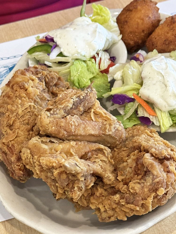Fried chicken so perfectly golden it deserves its own trophy, making a compelling case for ordering poultry at a seafood joint.